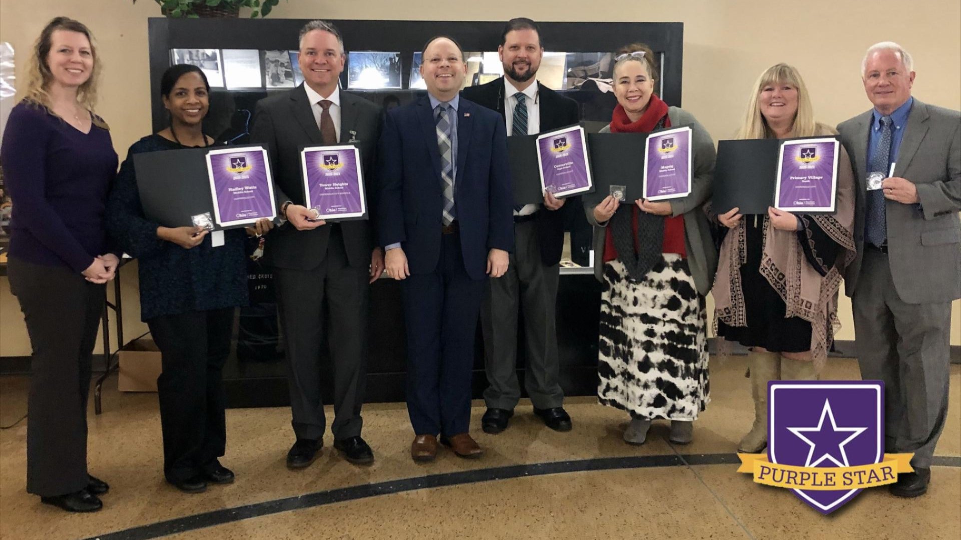 Image of eight people holding certificates