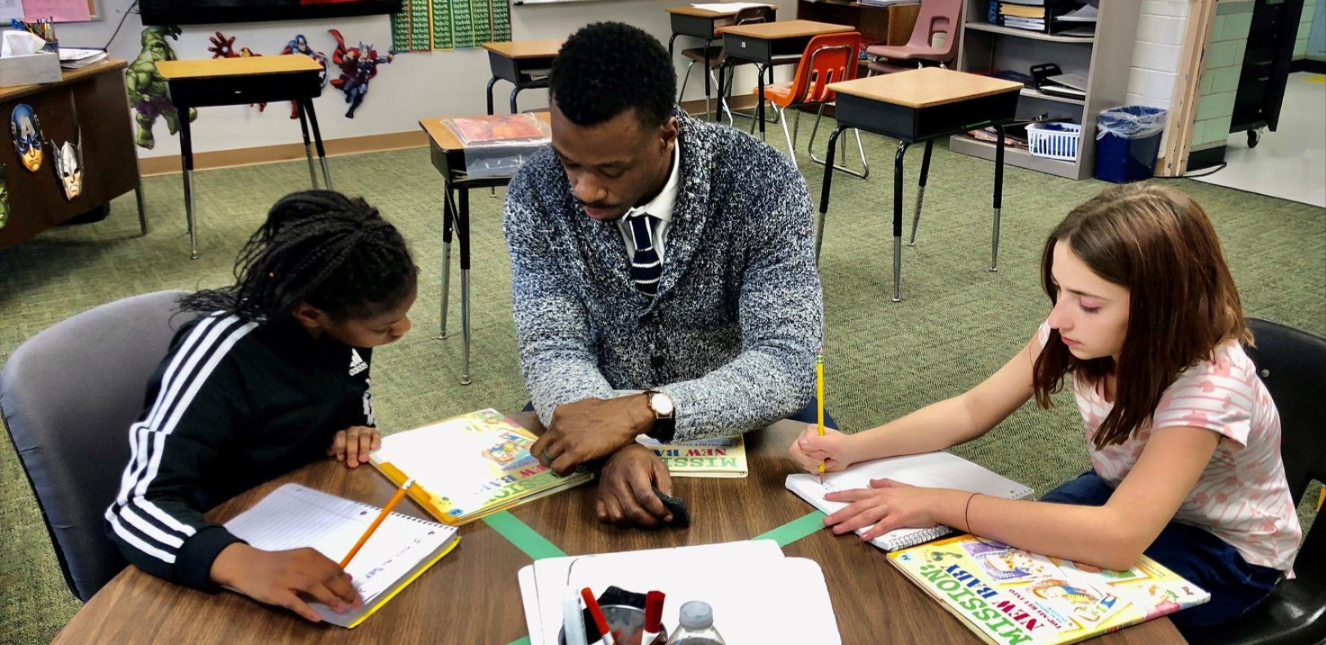 Image of intervention specialist working with two students in a classroom