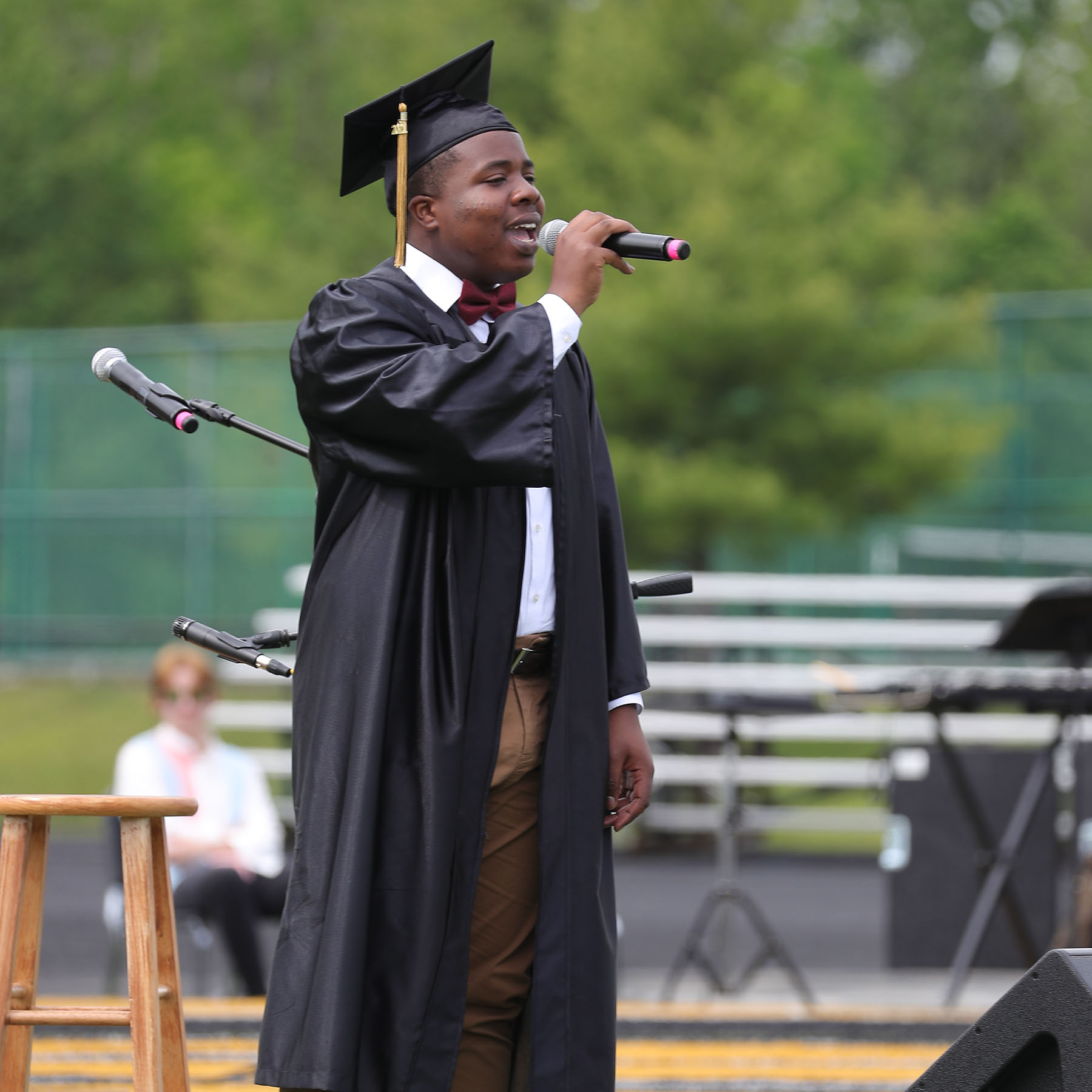 Image of graduate singing into microphone